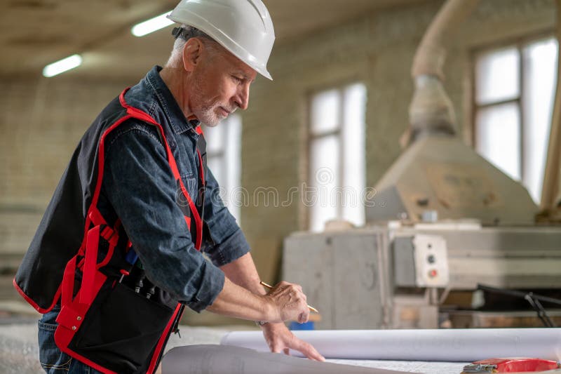 Man in Protective Helmet Working in a Workshop with Drawings Stock ...