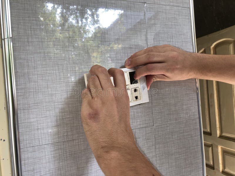 Electrician Technician at Work Sticks the Cable between the Clamps of a ...