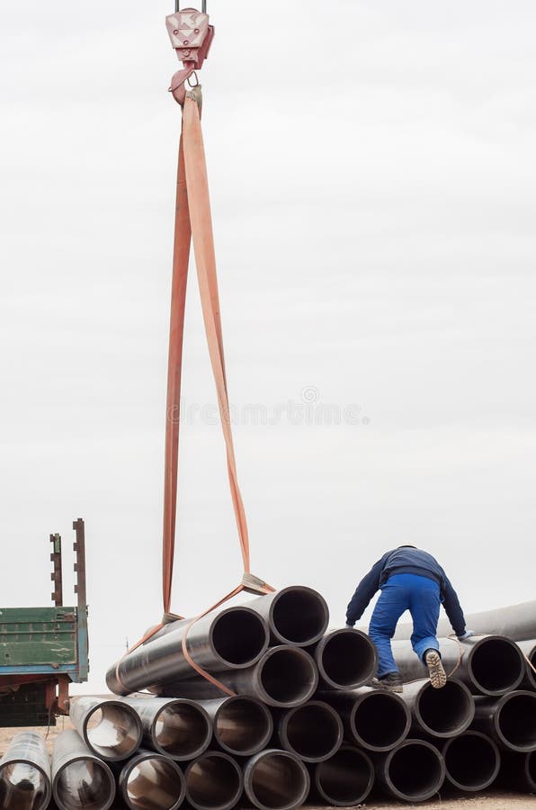 Work on Unloading of Pipes for Construction. Stock Image - Image of ...