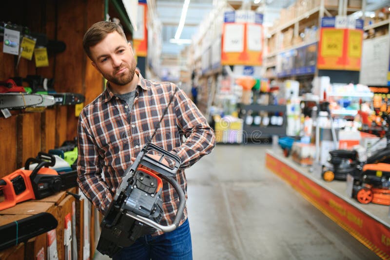 Worke Holds Electric Saw in Tool Store Stock Photo - Image of male ...