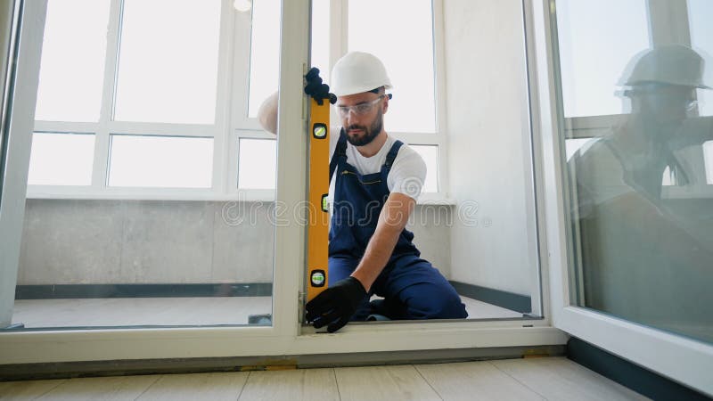 Worker Aligning PVC Door Frame with Level for Accurate Installation ...