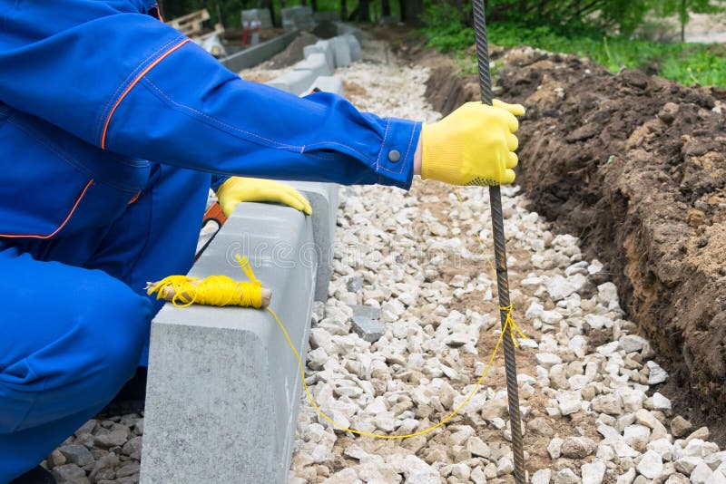 Worker Aligns Curbstone with Yellow Rope Stock Image - Image of copy ...