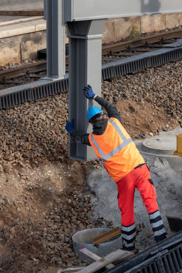 A Worker Performs Heavy Labor with a Large Steel Part Stock Image ...