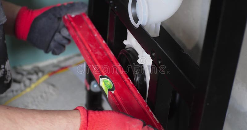 A Worker Applying a Spirit Level Tool To a Plastic Pipe To Check the ...