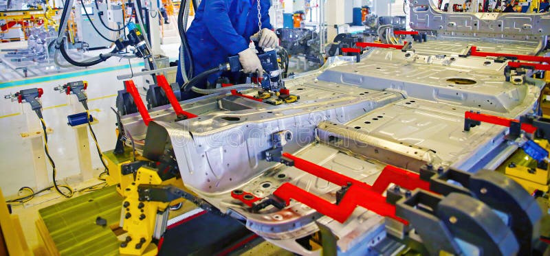 Worker Assembling a Car Chassis at an Automotive Manufacturing Facility ...