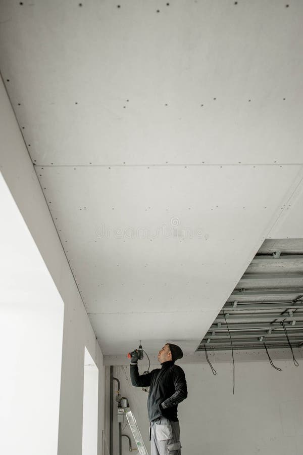 The Worker Attaches Plasterboard on Metal Frame. Installation of ...
