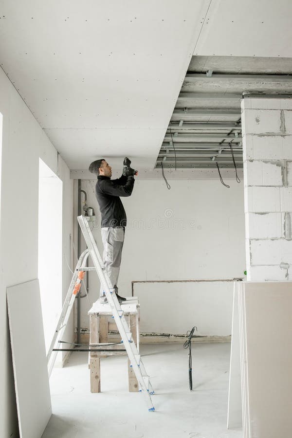 The Worker Attaches Plasterboard on Metal Frame. Installation of ...