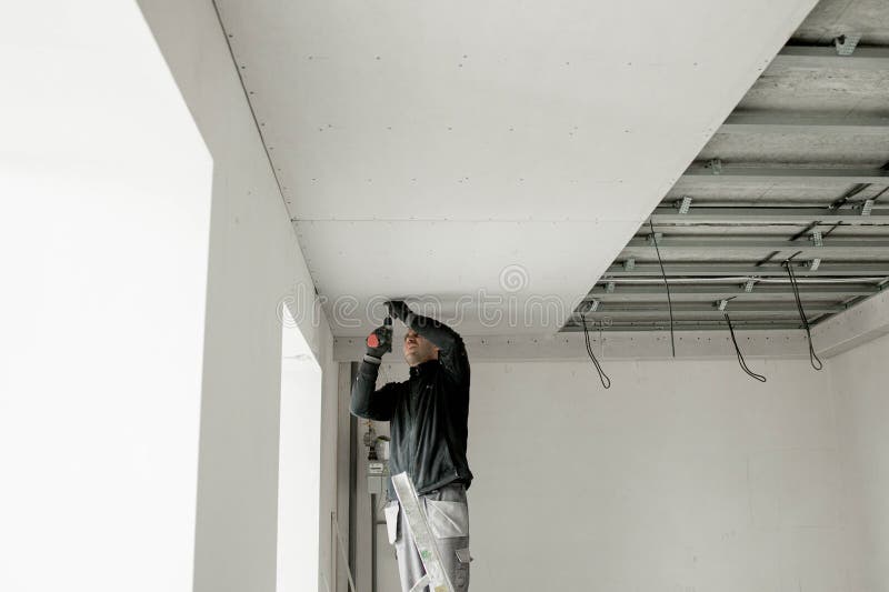 The Worker Attaches Plasterboard on Metal Frame. Installation of ...