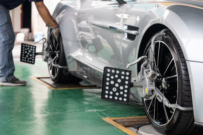 Mechanic Attaching the Wheel Alignment Device Onto the Wheel at ...