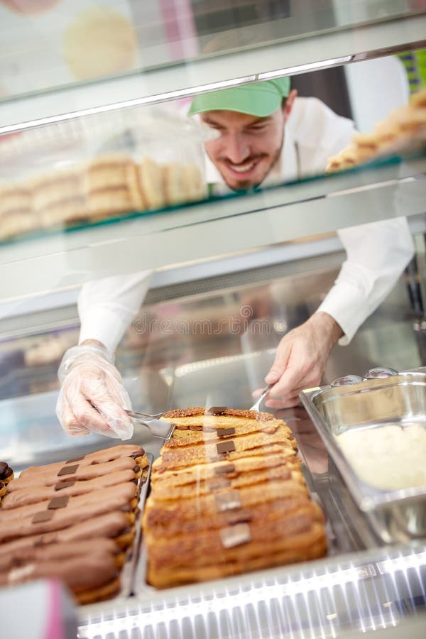 Worker in Bakery Taking Out Biscuit Cake from Showcase Stock Photo ...
