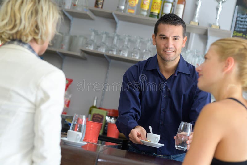 Worker in Bar Serving Two Female Clients Stock Photo - Image of counter ...