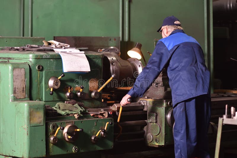 The Worker in Blue Workwear, the Operator of the CNC Machine, Oversees ...