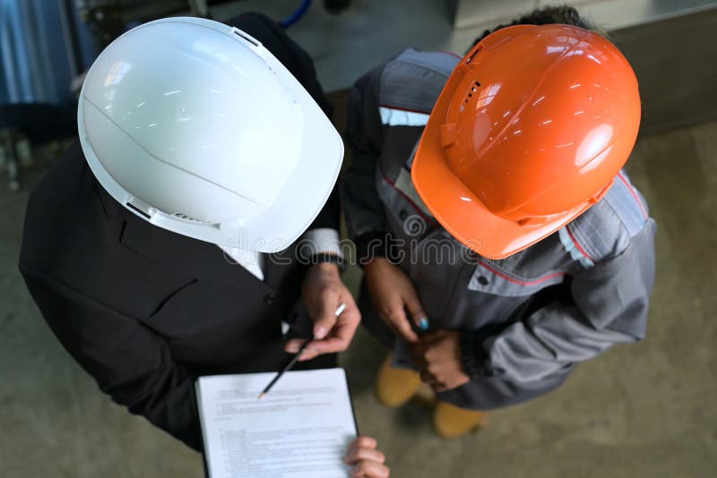 Worker and Boss in Orange and White Helmets Talking about Work in ...