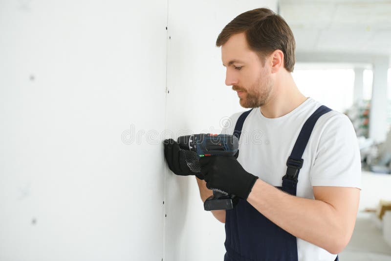 Worker Builder Installs Plasterboard Drywall at a Construction Stock ...