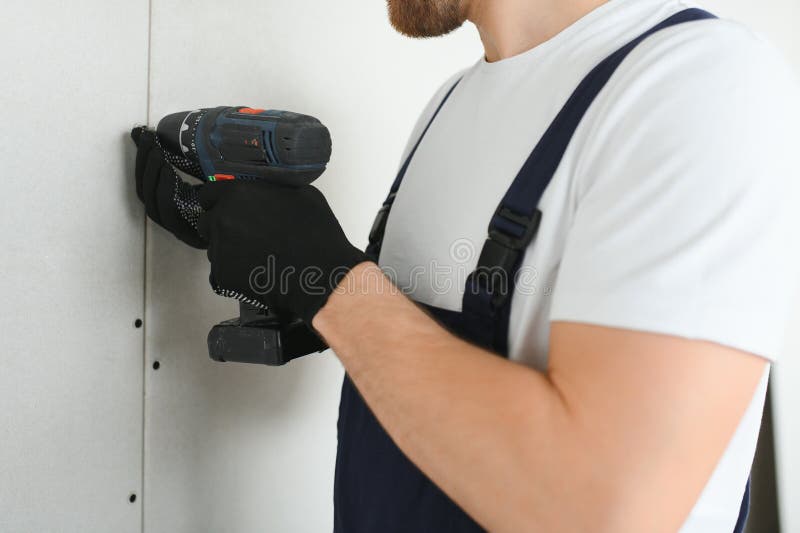 Worker Builder Installs Plasterboard Drywall at a Construction Stock ...