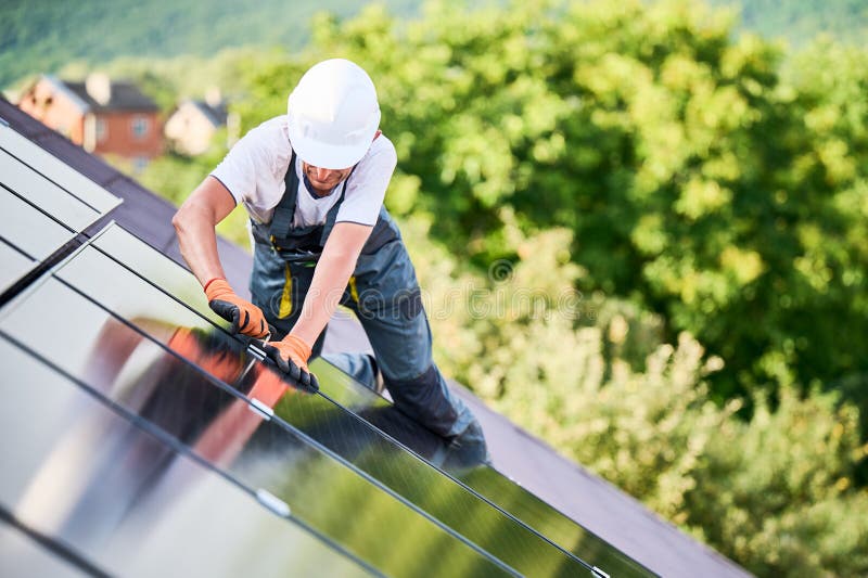 Worker Building Photovoltaic Solar Panel System on Rooftop of House ...