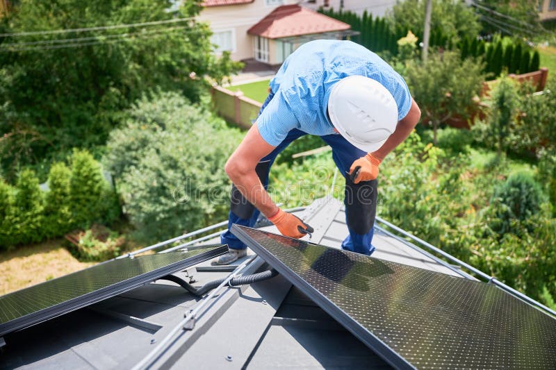 Worker Building Photovoltaic Solar Panel System on Rooftop of House ...