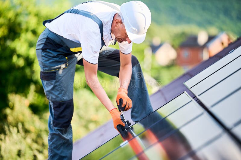 Worker Building Photovoltaic Solar Panel System on Rooftop of House ...
