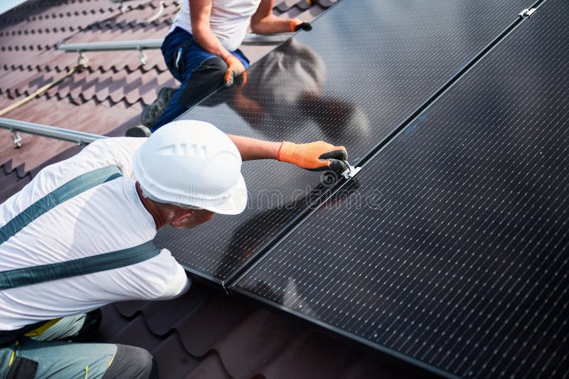 Worker Building Photovoltaic Solar Panel System on Rooftop of House ...