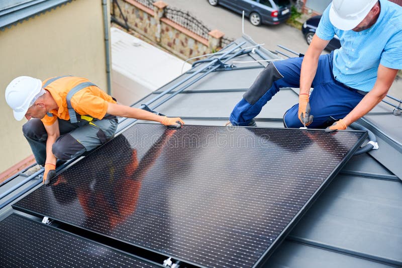 Worker Building Photovoltaic Solar Panel System on Rooftop of House ...