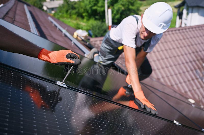 Worker Building Photovoltaic Solar Panel System on Rooftop of House ...