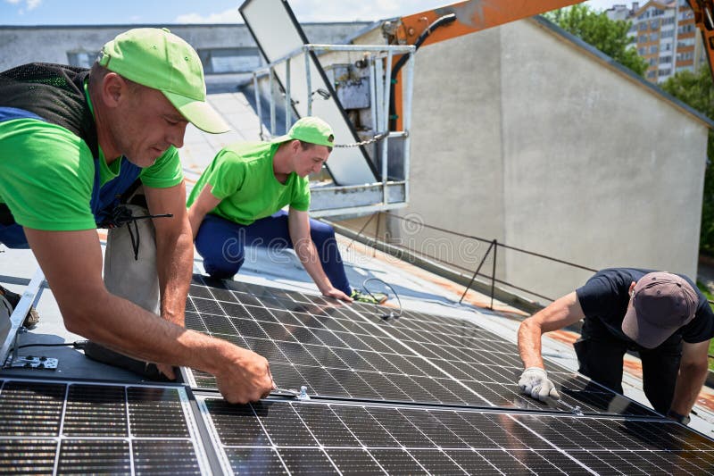 Worker Building Photovoltaic Solar Panel System on Rooftop of House ...