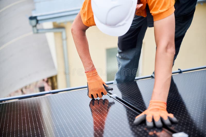 Worker Building Photovoltaic Solar Panel System on Rooftop of House ...