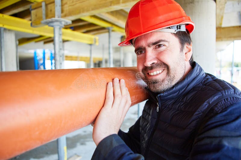 Worker on Building Site in the Shell Construction Carries a Drainpipe ...