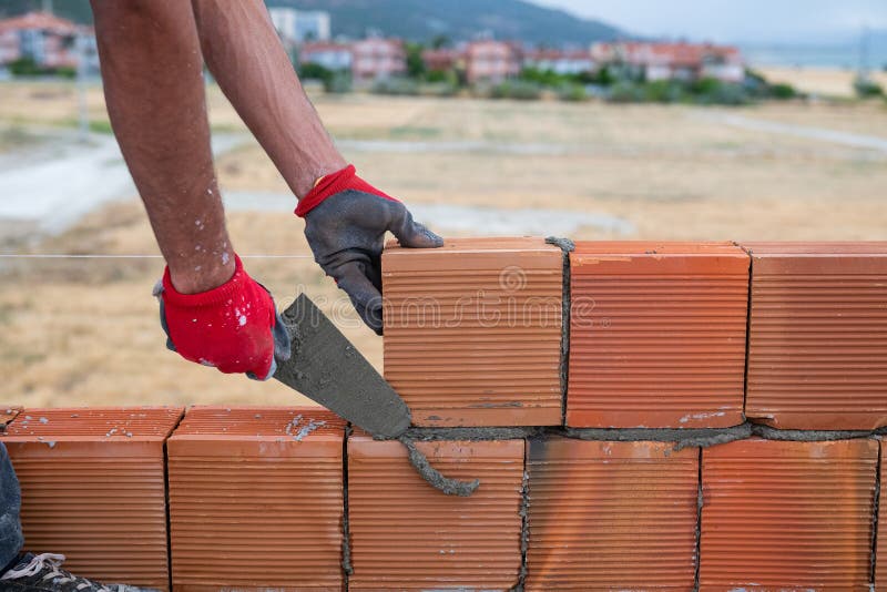 Worker Builds a Brick Wall for House Construction. Worker Building a ...