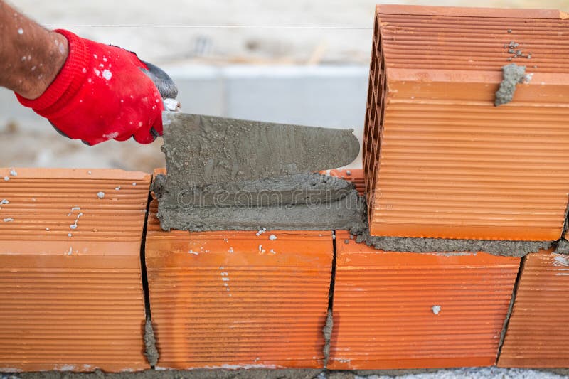 Worker Builds a Brick Wall for House Construction. Worker Building a ...