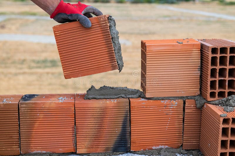Worker Builds a Brick Wall for House Construction. Worker Building a ...