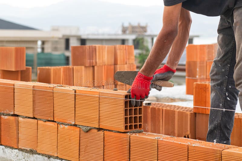 Worker Builds a Brick Wall for House Construction. Worker Building a ...