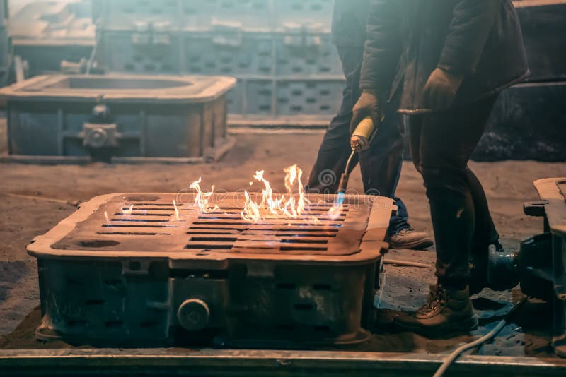 Worker Burns Mold Container with Fire after Smelting Metal Close Up ...