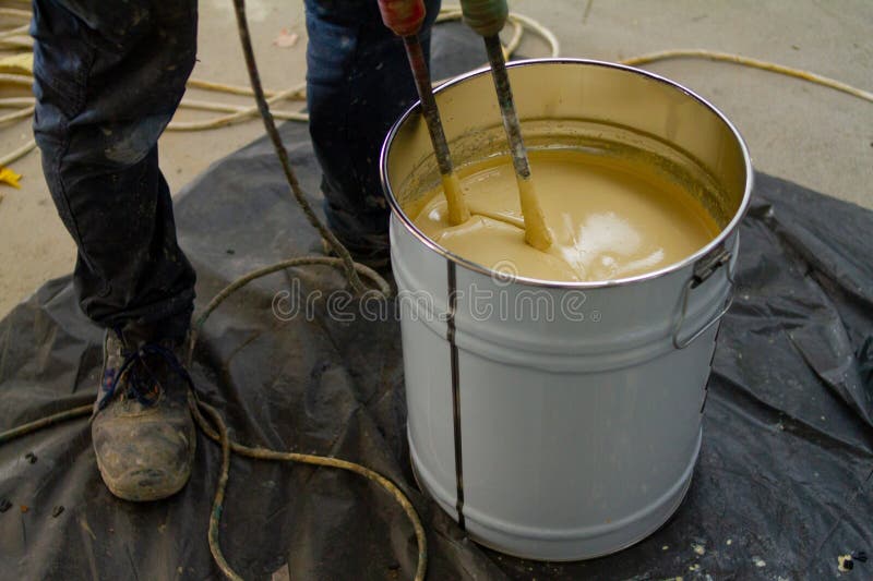The Worker is Carefully Mixing Epoxy Composites in a Metal Bucket To ...