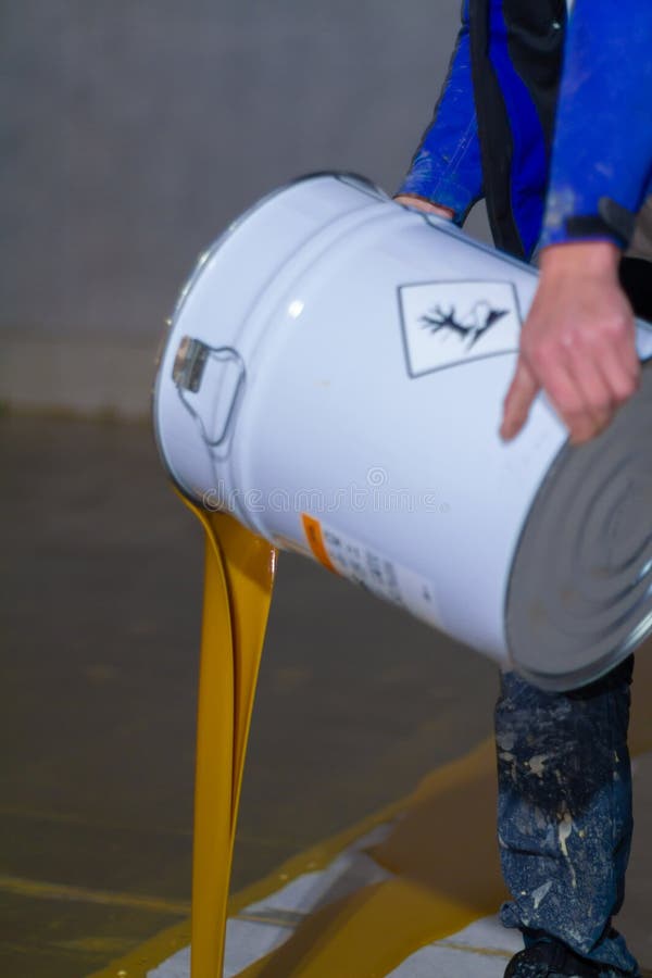Worker is Carefully Pouring Yellow Epoxy Resin Primer from a Bucket ...