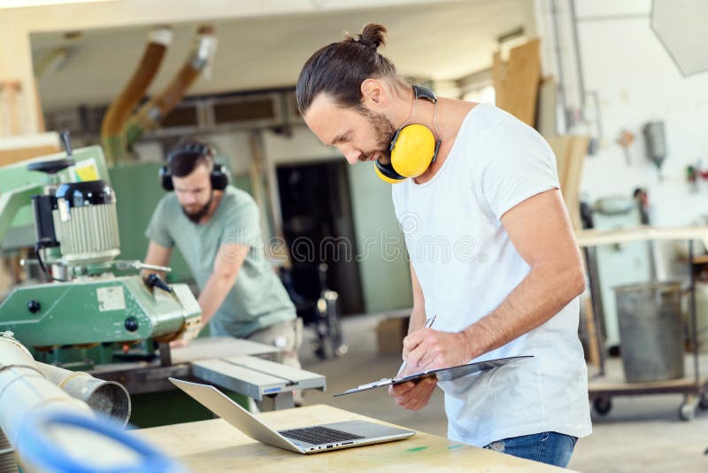 Worker in a Carpenter`s Workshop with Computer and Clipboard Stock ...