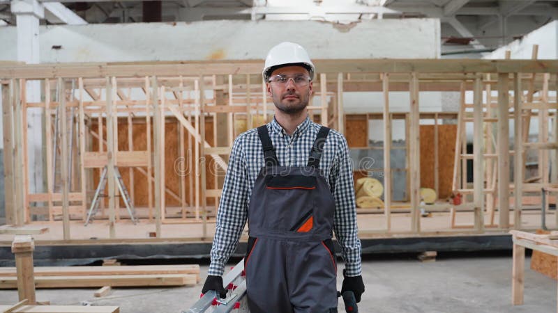 Worker Carpenter in Uniform Walks with Tools Near Unfinished ...