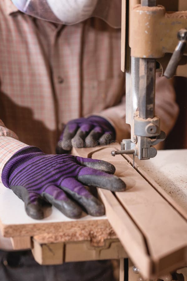 Worker in the Carpentry Workshop Cuts the Wooden Board Using Band Saw ...