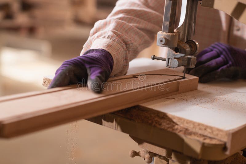 Worker in the Carpentry Workshop Cuts the Wooden Board Using Band Saw ...