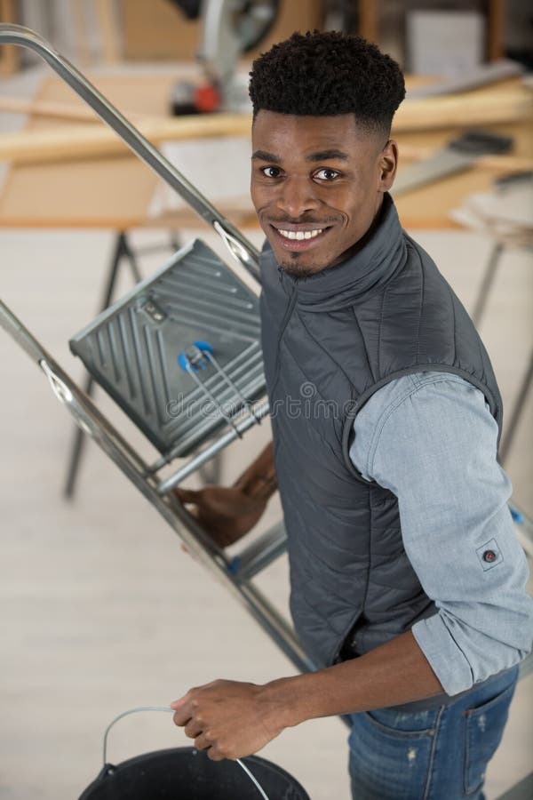 Worker Carrying Ladder at Construction Site Stock Photo - Image of ...