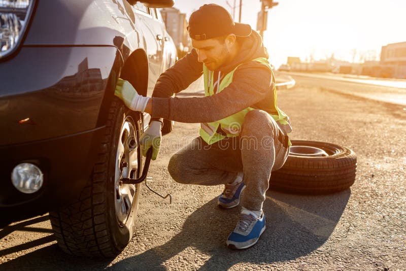 Worker Changes a Broken Wheel of a Car. the Driver Should Replace the ...