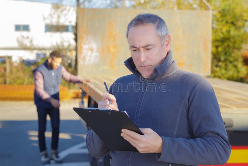 Worker Checking Clipboard in Shipping Yard Stock Photo - Image of ...