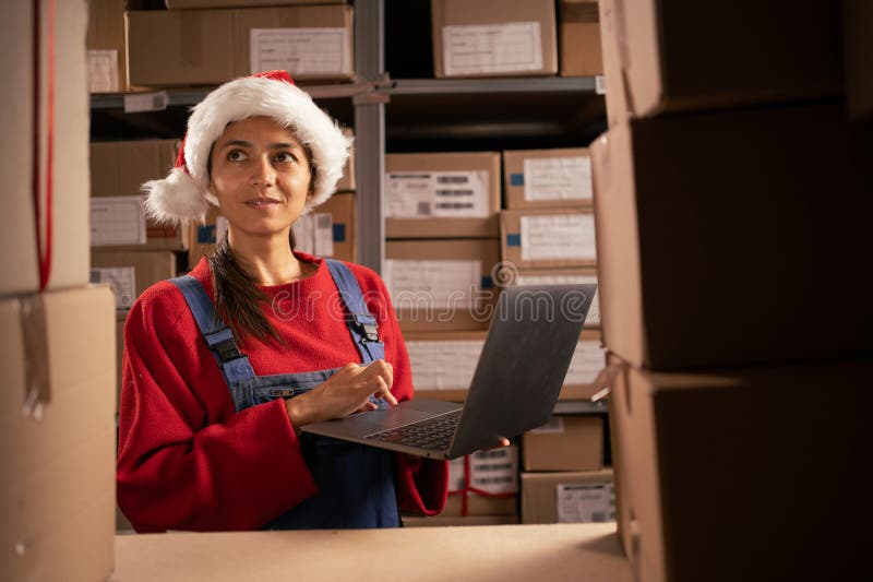 Worker Checking Inventory Using Laptop Computer. Young Female Santa ...