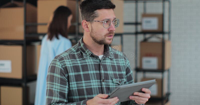 Worker Checking Inventory, Writing Notes on Tablet. a Man Works in a ...