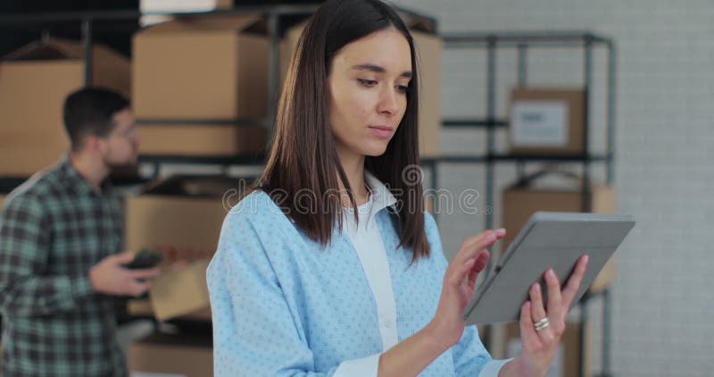 Worker Checking Inventory, Writing Notes on Tablet. a Woman Works in a ...