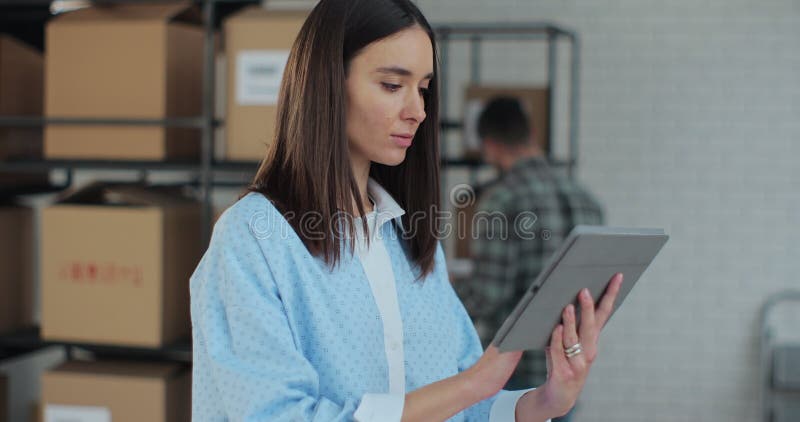 Worker Checking Inventory, Writing Notes on Tablet. a Woman Works in a ...
