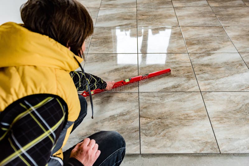 Worker Checks the Level of the Tile Floor. Stock Image - Image of ...