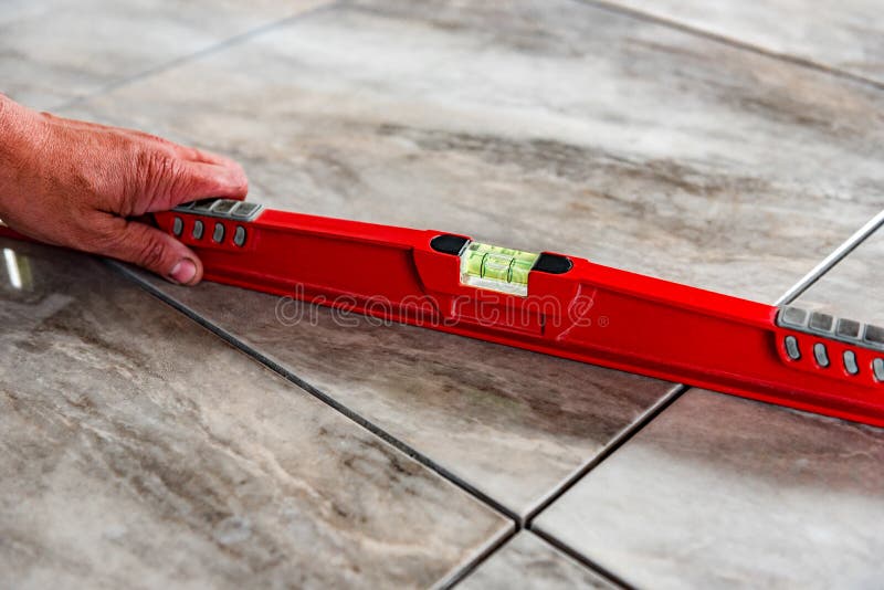 Worker Checks the Level of the Tile Floor. Stock Photo - Image of ...