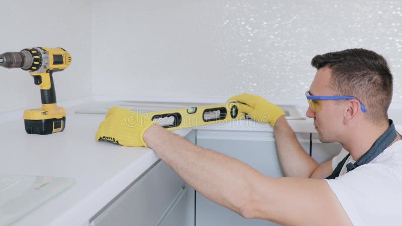 Worker Checks the Leveling of the Working Surface of the Kitchen Table ...