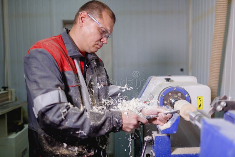 The Worker with a Chisel Gives a Round Shape To the Bar on the Machine ...